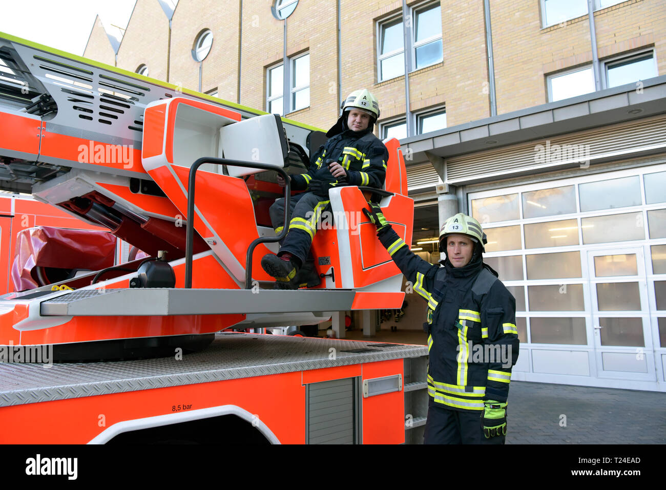 Portrait of two firefighters exercising at fire engine Stock Photo - Alamy