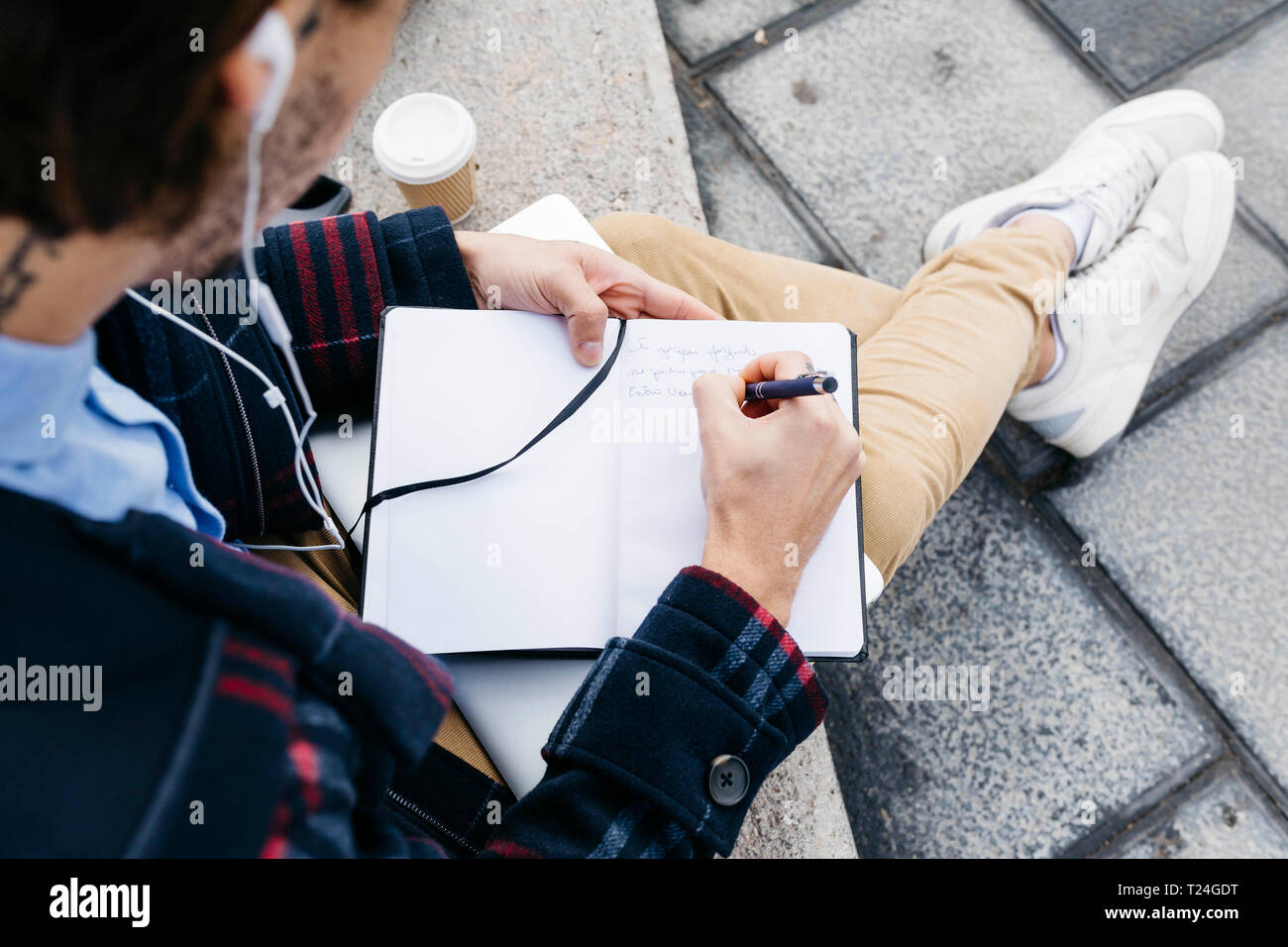 Man sitting outside taking notes Stock Photo - Alamy