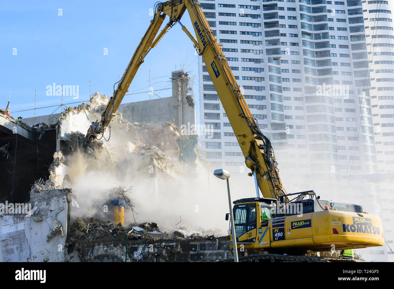 demolition of building (former cinema) with breaker, worker, highrise ...