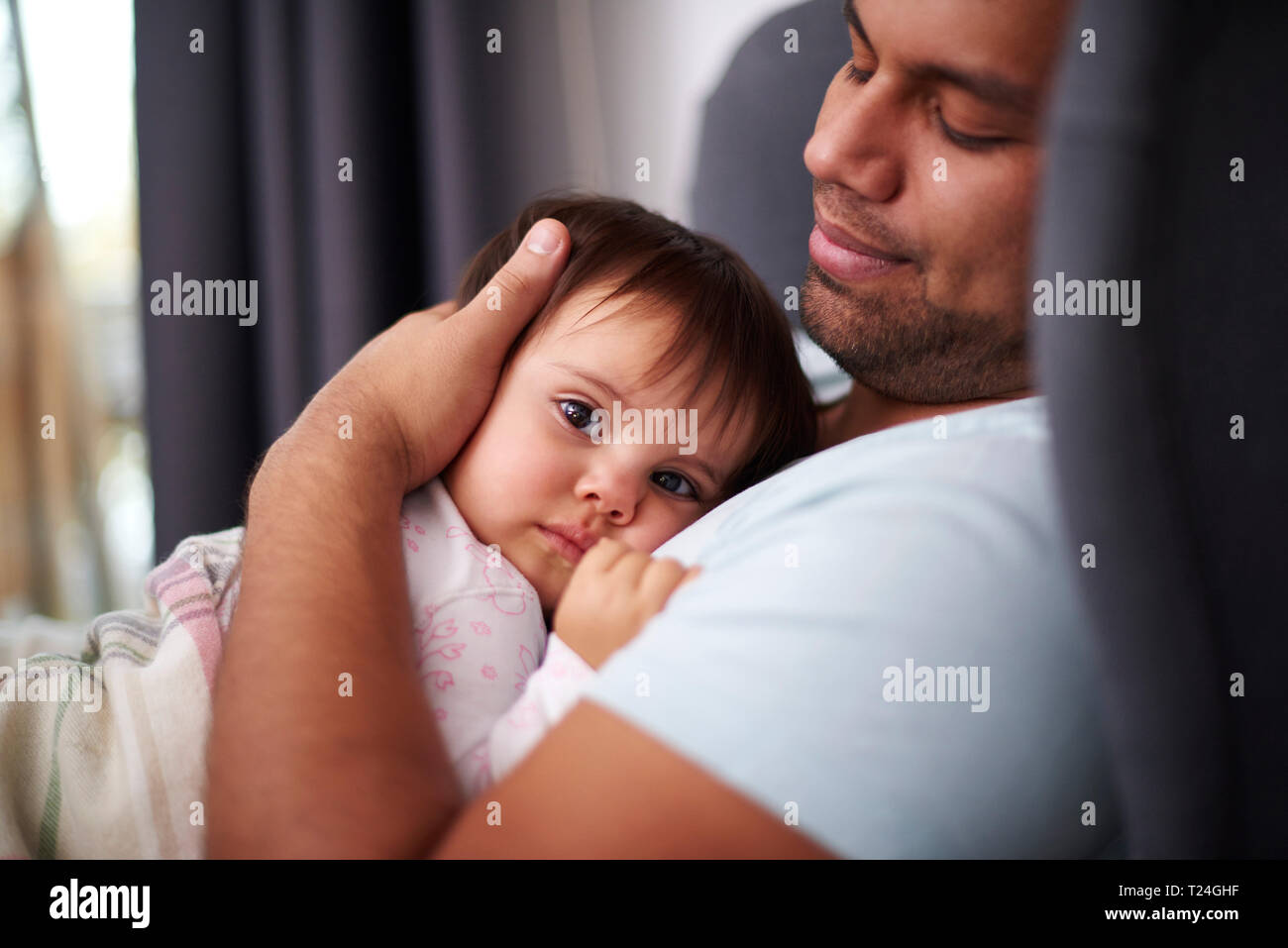 Affectionate father hugging his baby daughter at home Stock Photo - Alamy