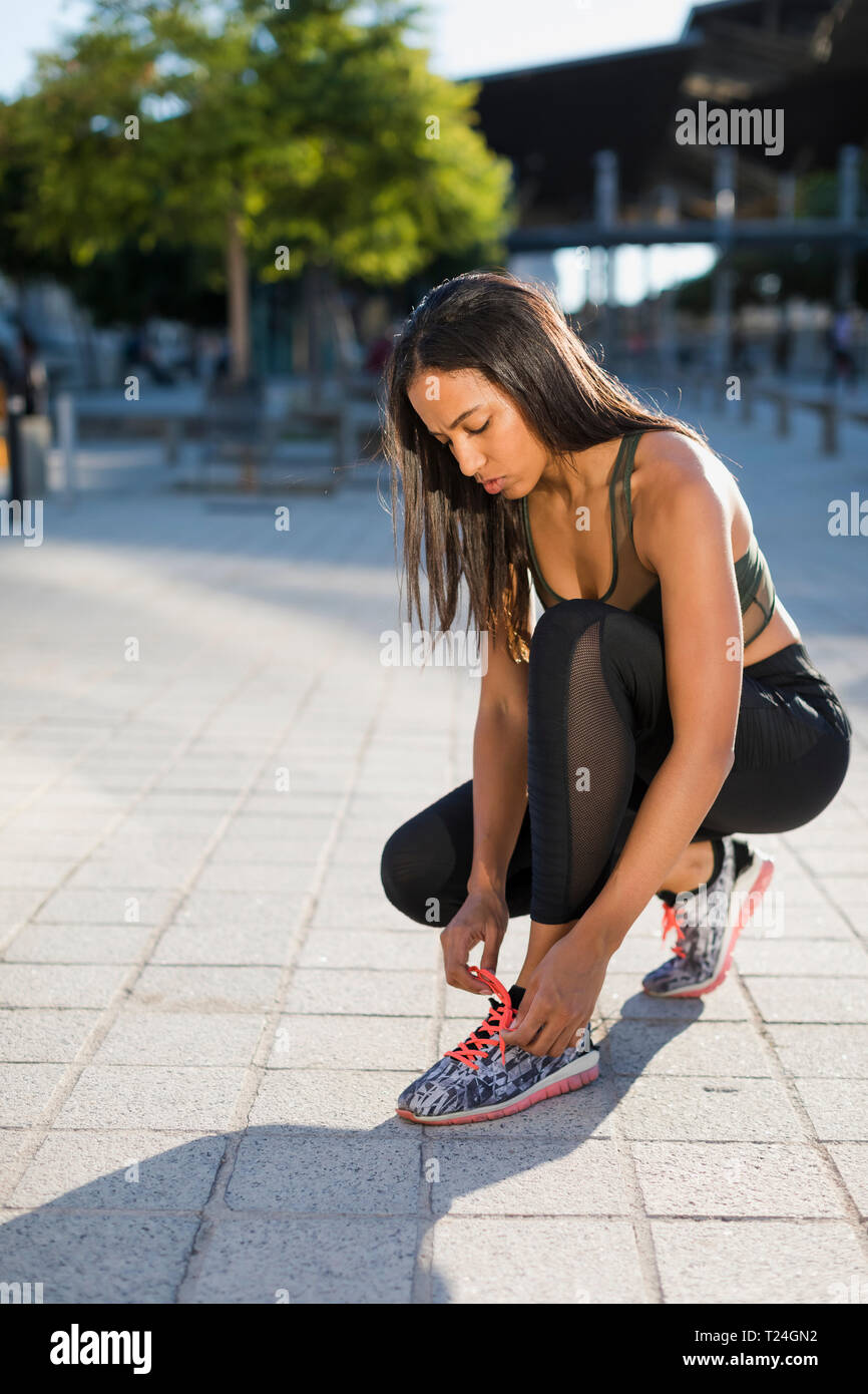 Woman tying her shoes hi-res stock photography and images - Alamy