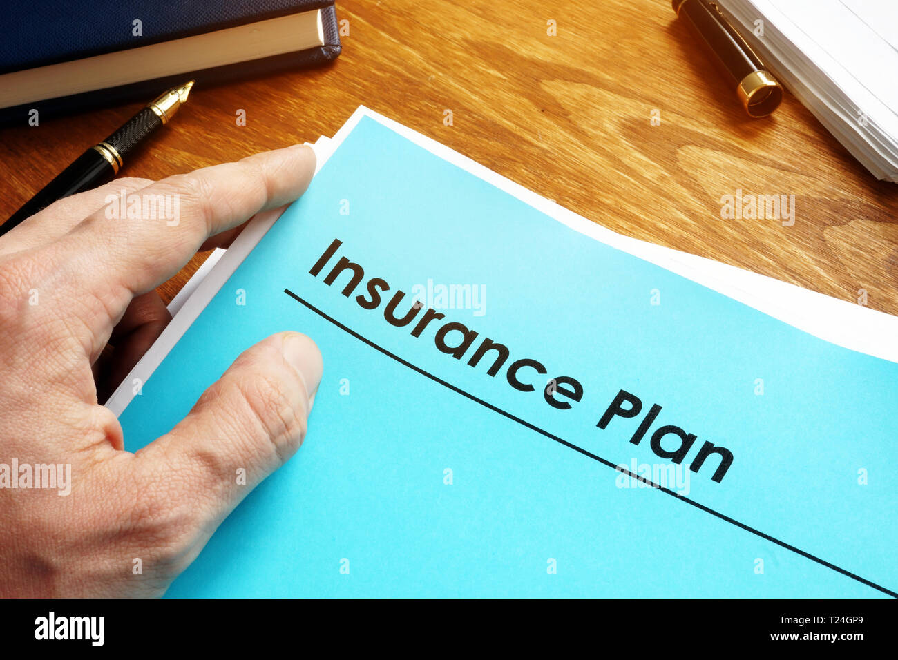Insurance Plan policy papers on desk Stock Photo - Alamy