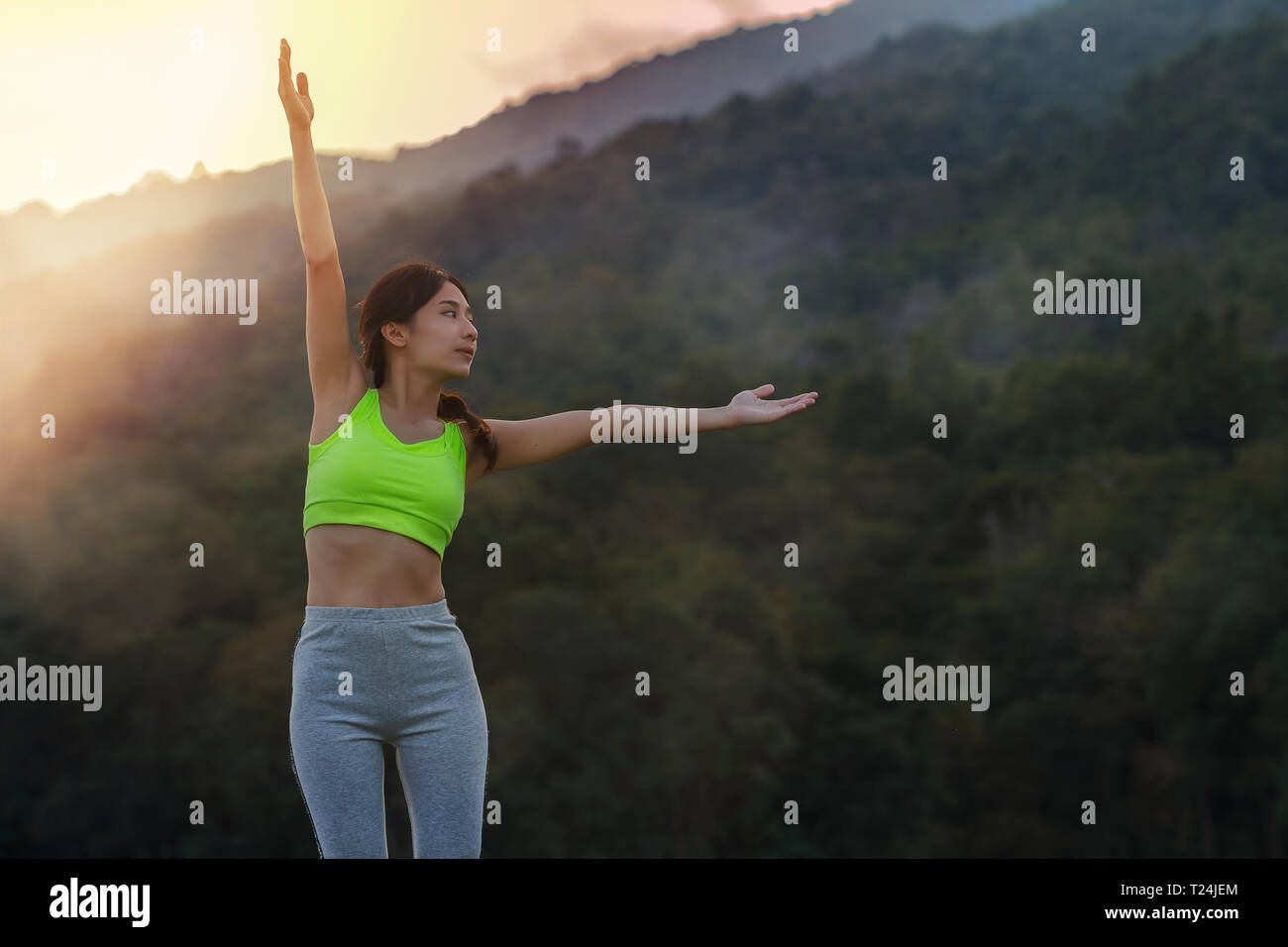 Young asian woman runner raise her hand up to resting after workout ...
