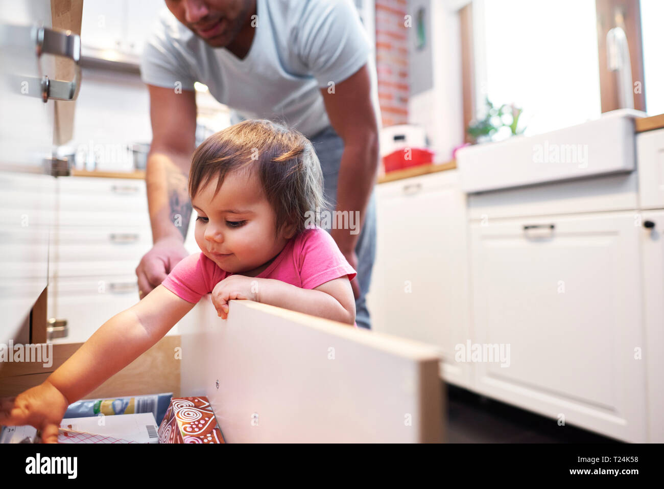 Baby girl helping father in kitchen at home Stock Photo - Alamy