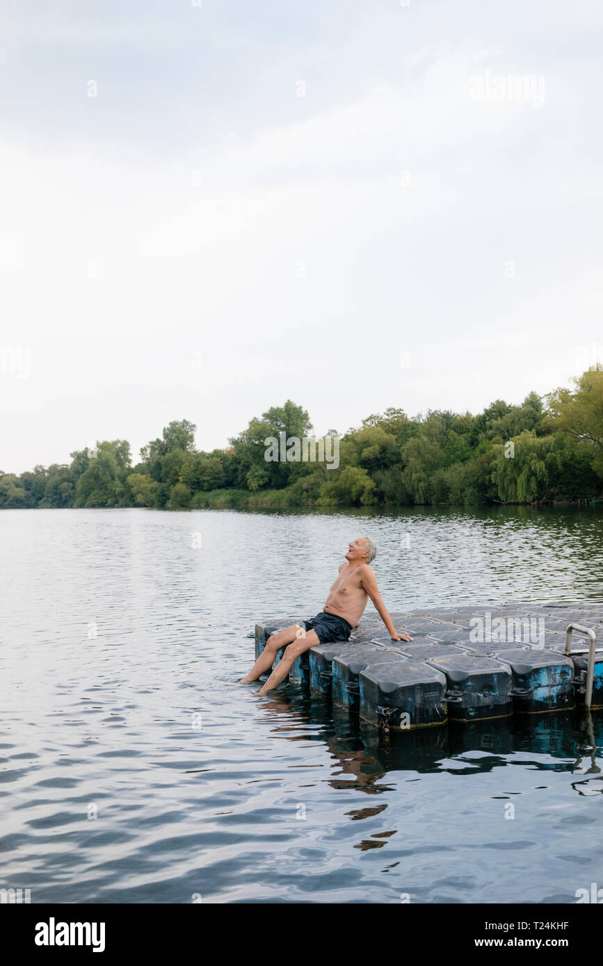 Senior man sitting on raft in a lake Stock Photo - Alamy