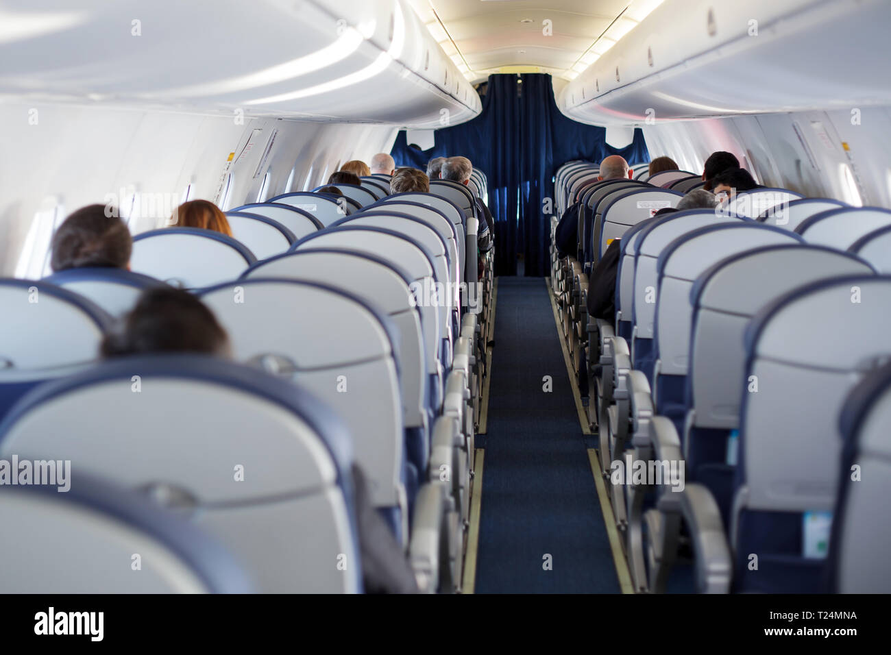 Half-empty airplane with few passengers. Passengers inside the cabin of ...