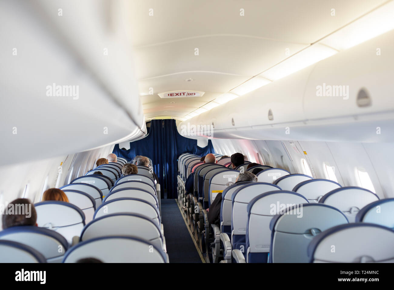 Half-empty airplane with few passengers. Passengers inside the cabin of ...