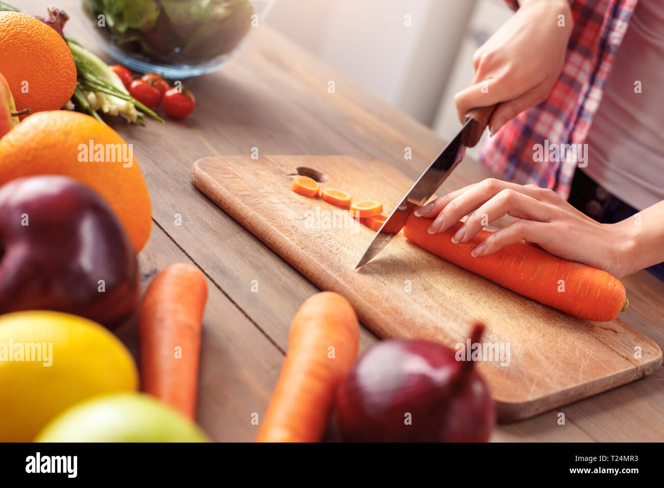 Young woman at kitchen healthy lifestyle standing holding knife cutting ...