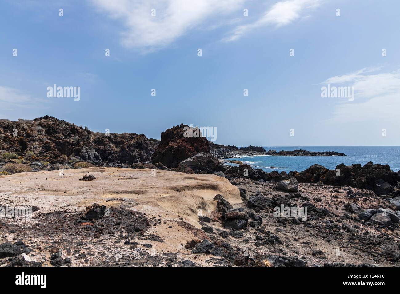 Sandy coloured soft rock and hard volcanic basalt along the coastal ...