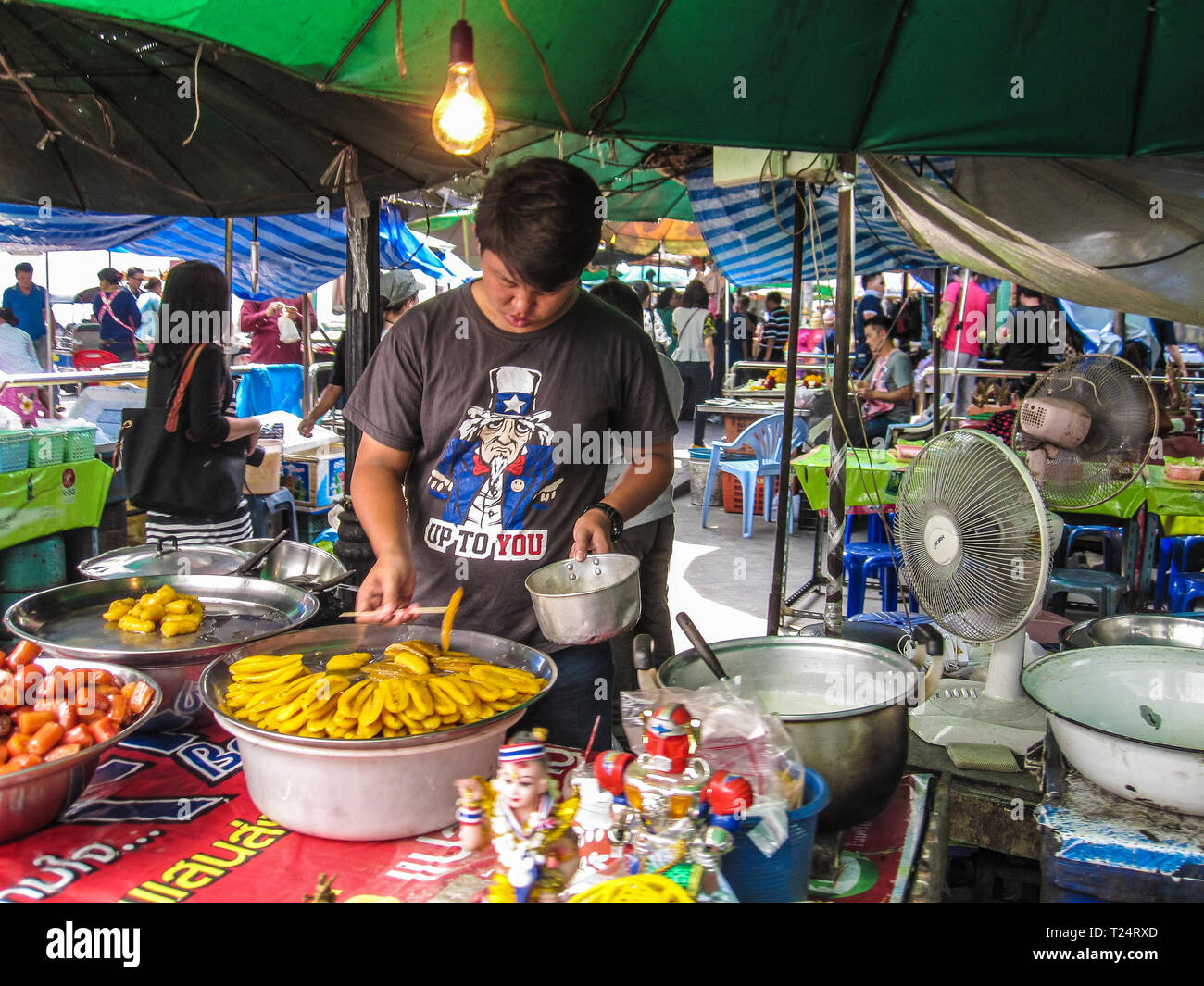 Bangkok December 2013: Man cooking pisang goreng or fried bananas in ...
