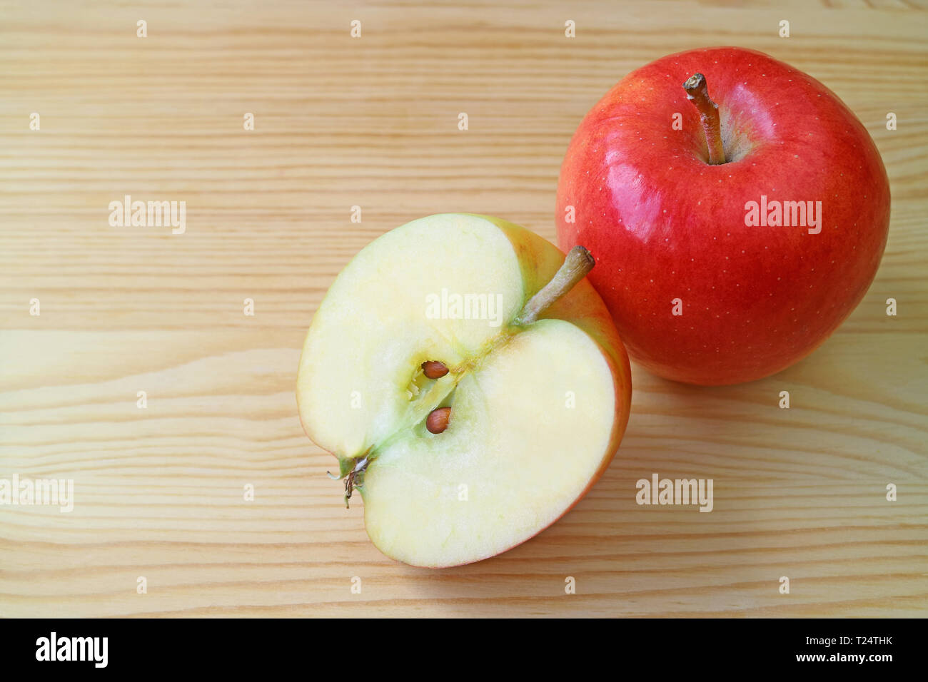 Fresh red apple whole fruit and its cross section on wooden table with ...