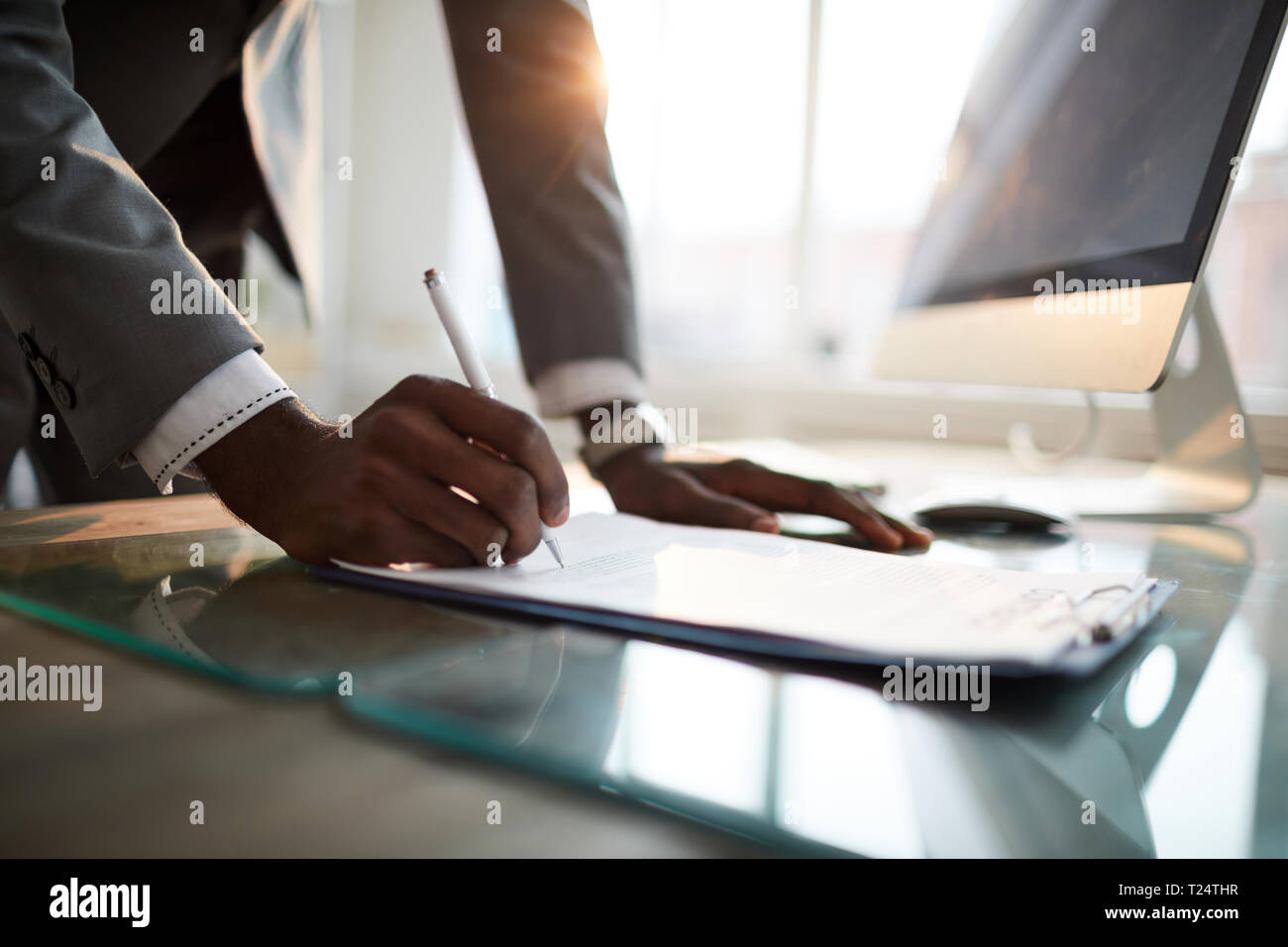 Putting signature on paper Stock Photo - Alamy