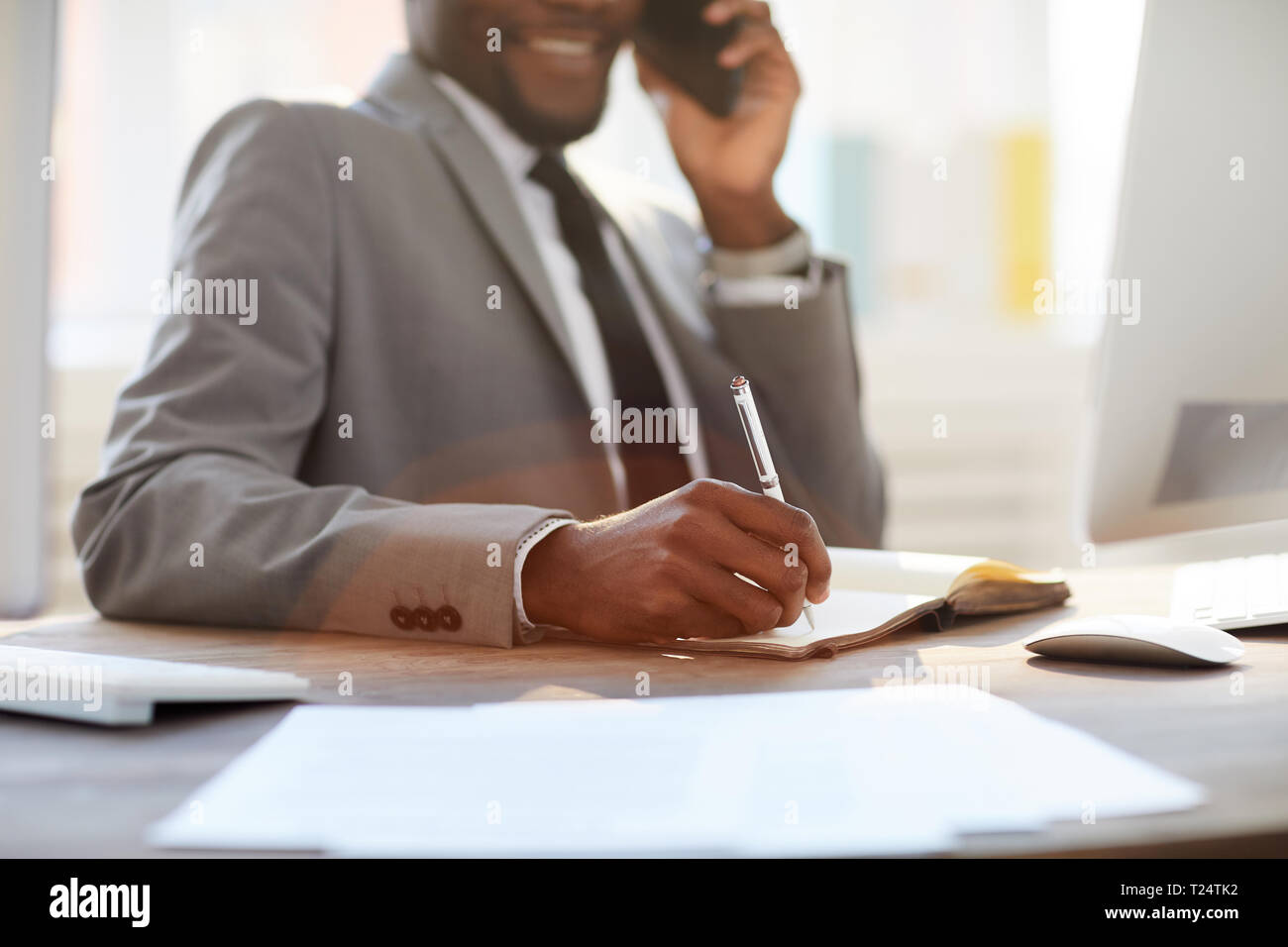 Phoning and making notes Stock Photo - Alamy