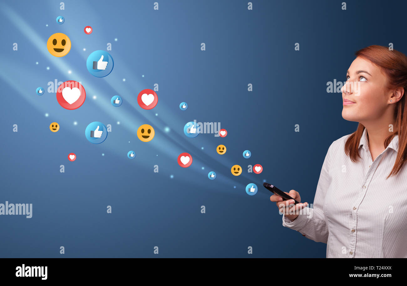 Young person using smartphone with flying social media icons around ...