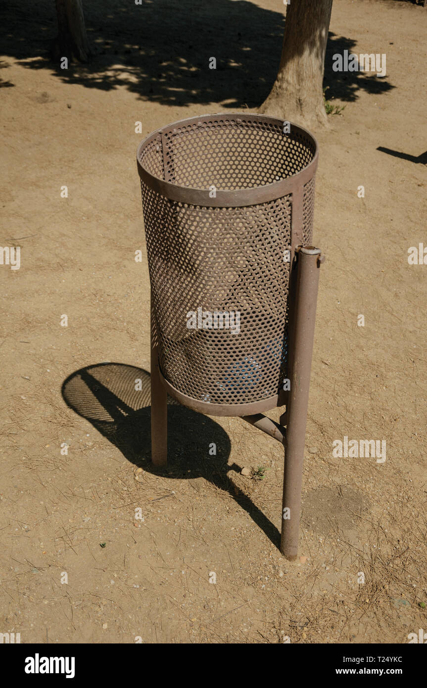 Metallic public trash can with its shadow in a park of Merida. The city ...