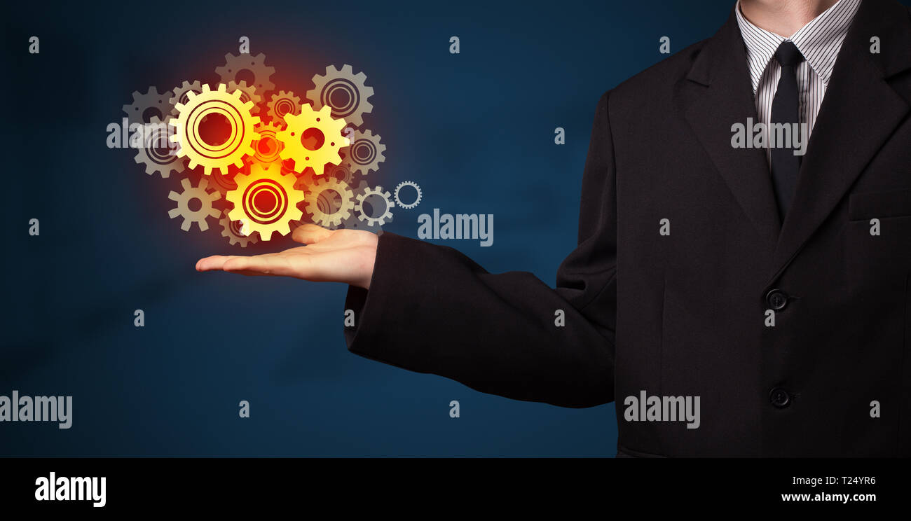 Hand holding gears in his hand Stock Photo - Alamy