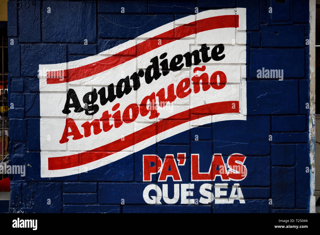 Textured blue wall with Colombia's national alcoholic beverage logo ...