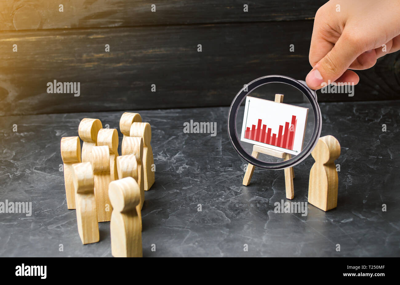 Magnifying glass is looking at the people gathered for a meeting or ...