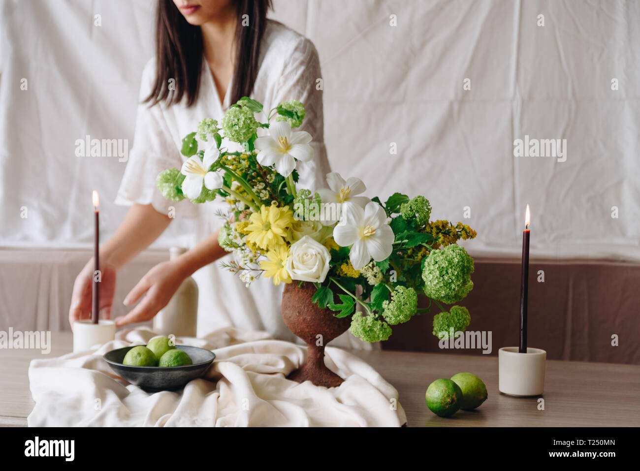 Woman touching candle. Still life with flower concept Stock Photo - Alamy