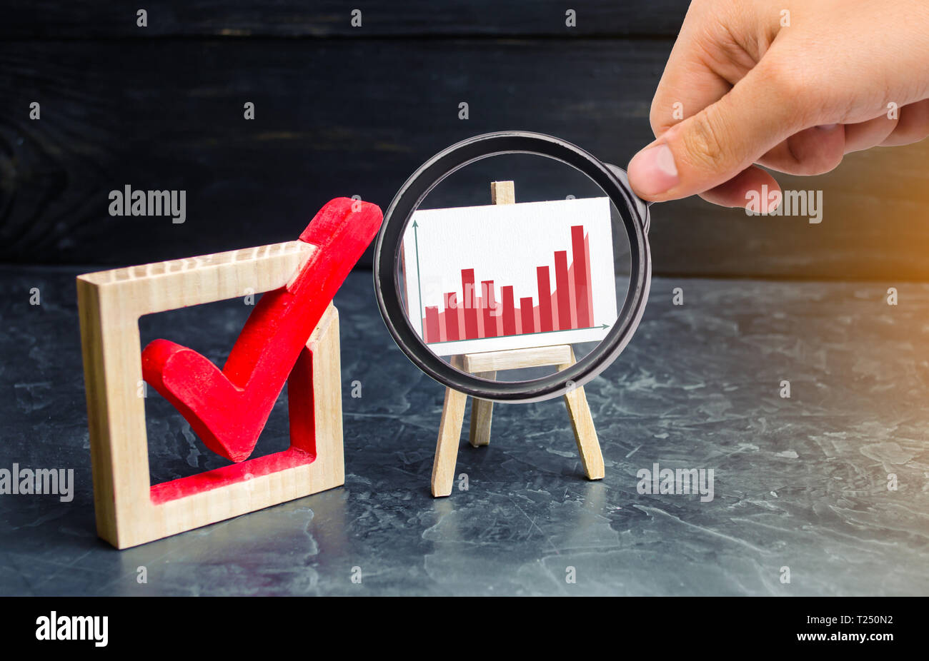 Magnifying glass is looking at the stand with a red graph and a check ...
