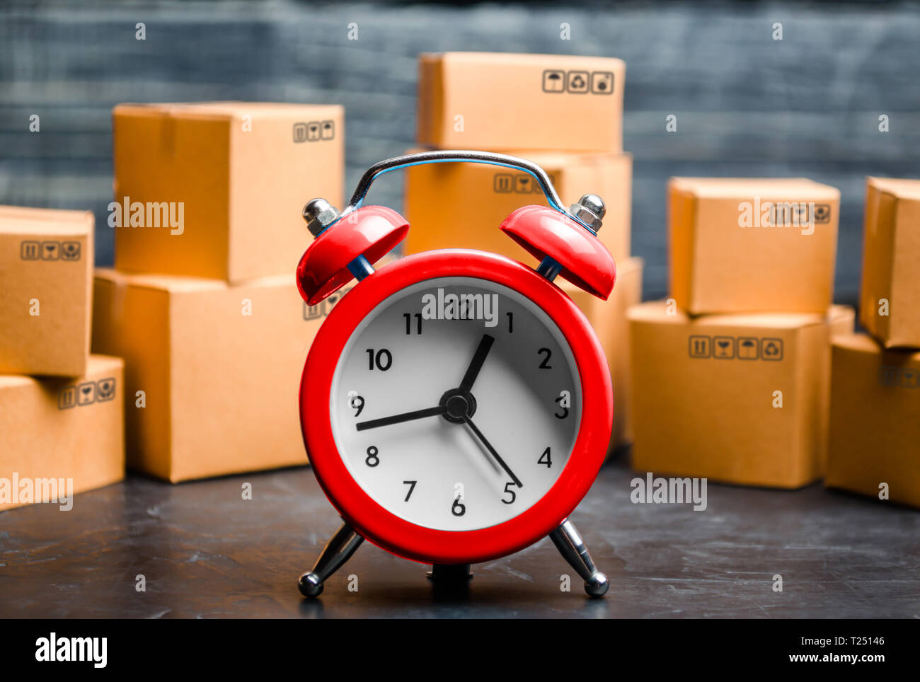 Cardboard boxes and red alarm clock. Time of delivery. Limited supply ...