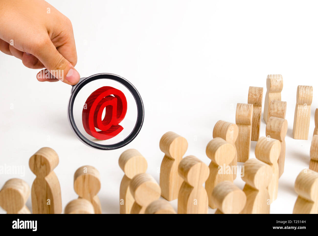 Magnifying glass is looking at the large crowd of people and a email ...