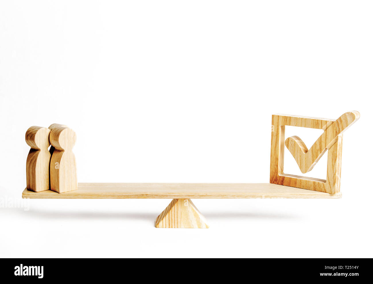 A group of wooden figures of people and wooden check mark on the scales ...