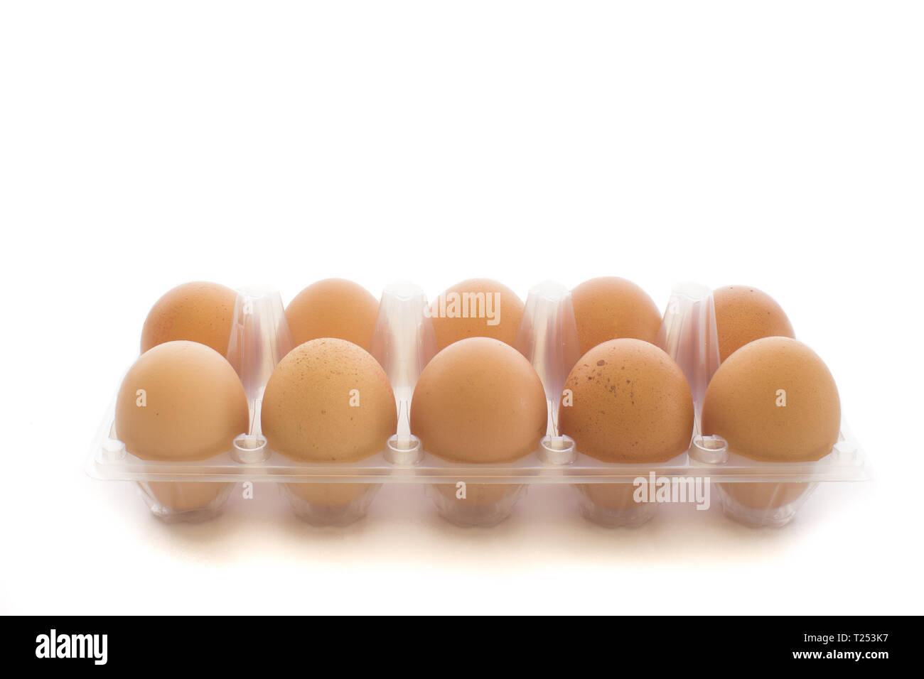 Close-up view of raw chicken eggs in transparent egg box isolated on ...