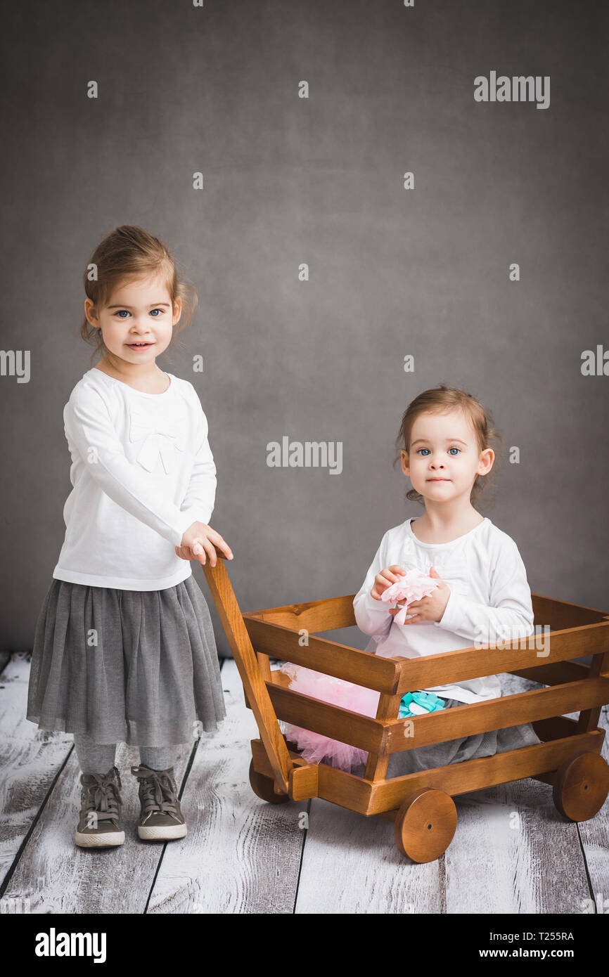 two cute and little girls are playing with trolley Stock Photo - Alamy