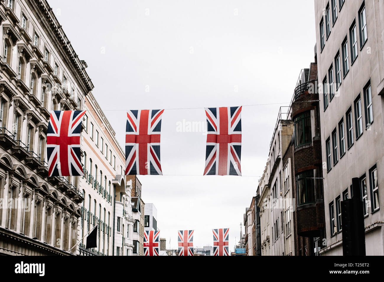 Union Jack flags hanging between two rows of buildings in London ...