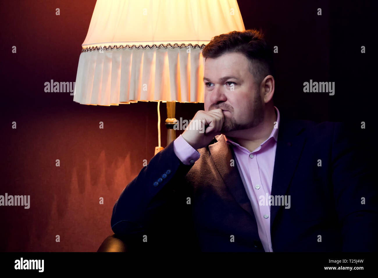 Solid man with a beard in a jacket sitting on the couch Stock Photo - Alamy