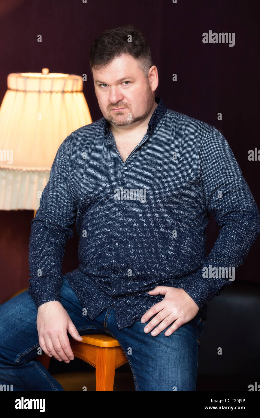 Male 40-45 years old with a beard on his face a shirt on a dark ...