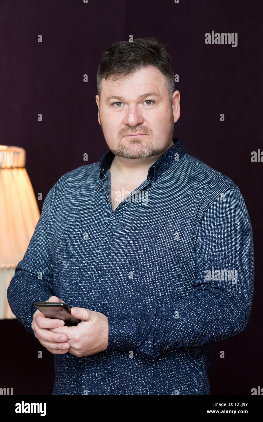 Male 40-45 years old with a beard on his face in a shirt on dark ...