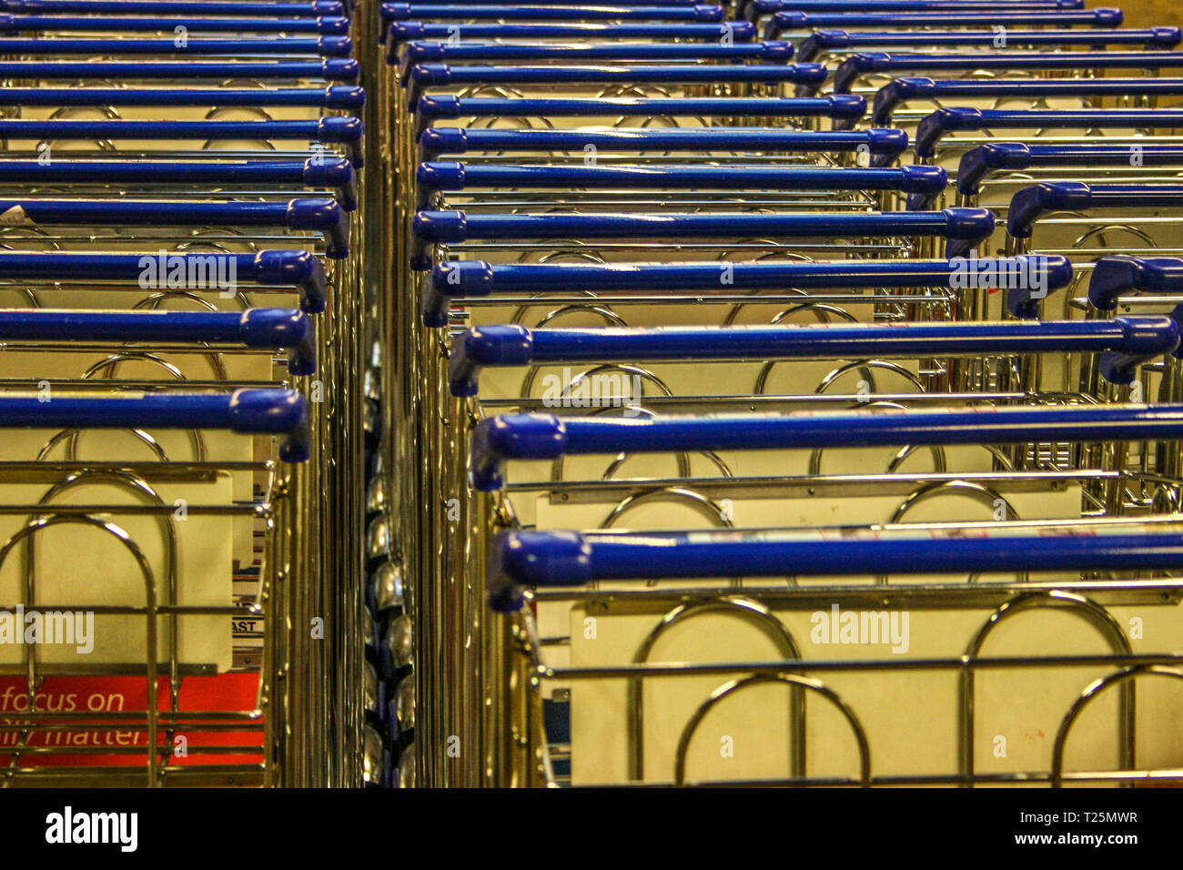 line of shopping trolleys with blue handrails in a shopping mall ...