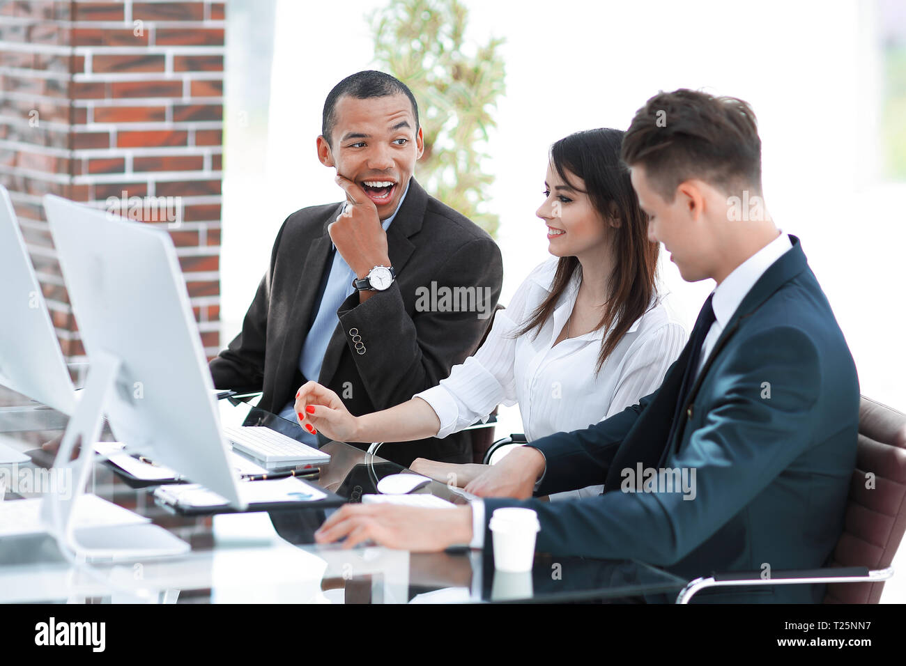 professional business team talking while sitting behind a Desk Stock ...