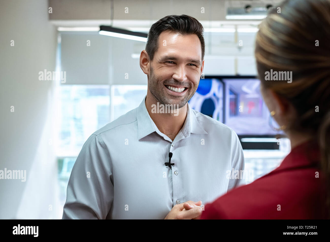 Happy businessman during corporate interview with female journalist ...