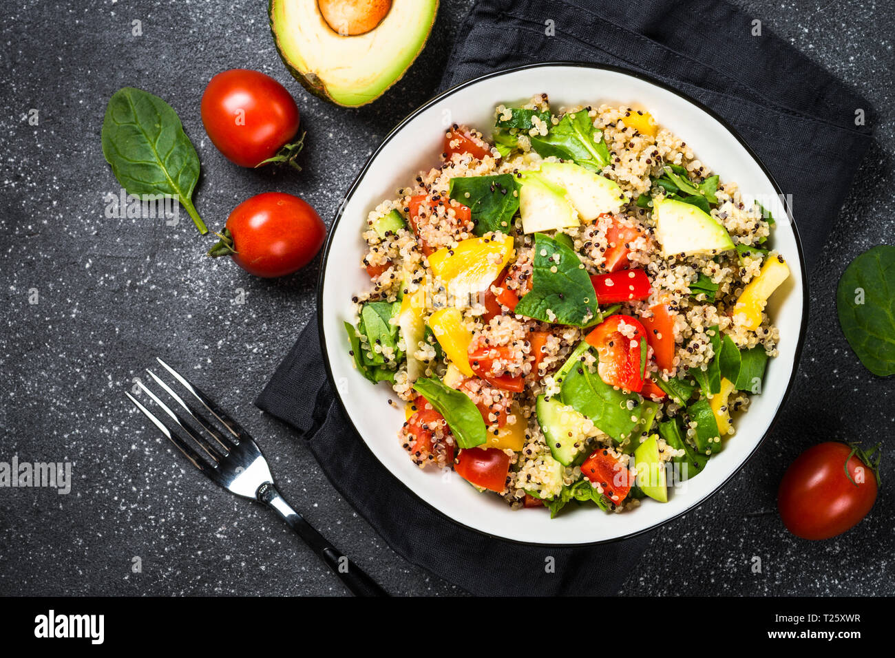 Quinoa salad with fresh vegetables on black Stock Photo - Alamy