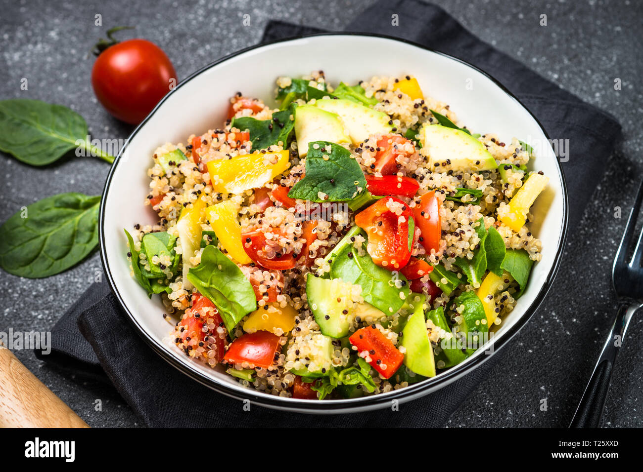 Quinoa salad with fresh vegetables on black Stock Photo - Alamy