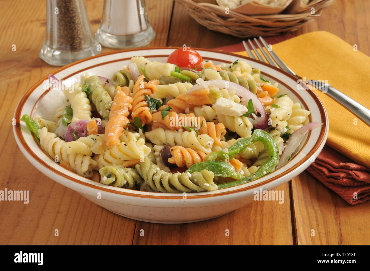 Mediterranean pasta salad with a small basket of dinner rolls Stock ...