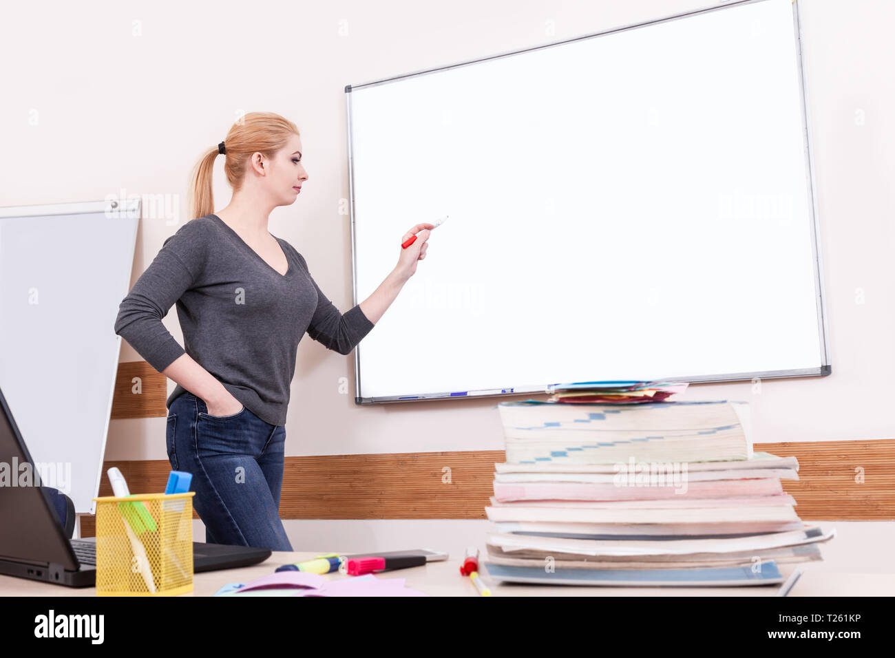Portrait of blonde young woman on the white background with computer ...
