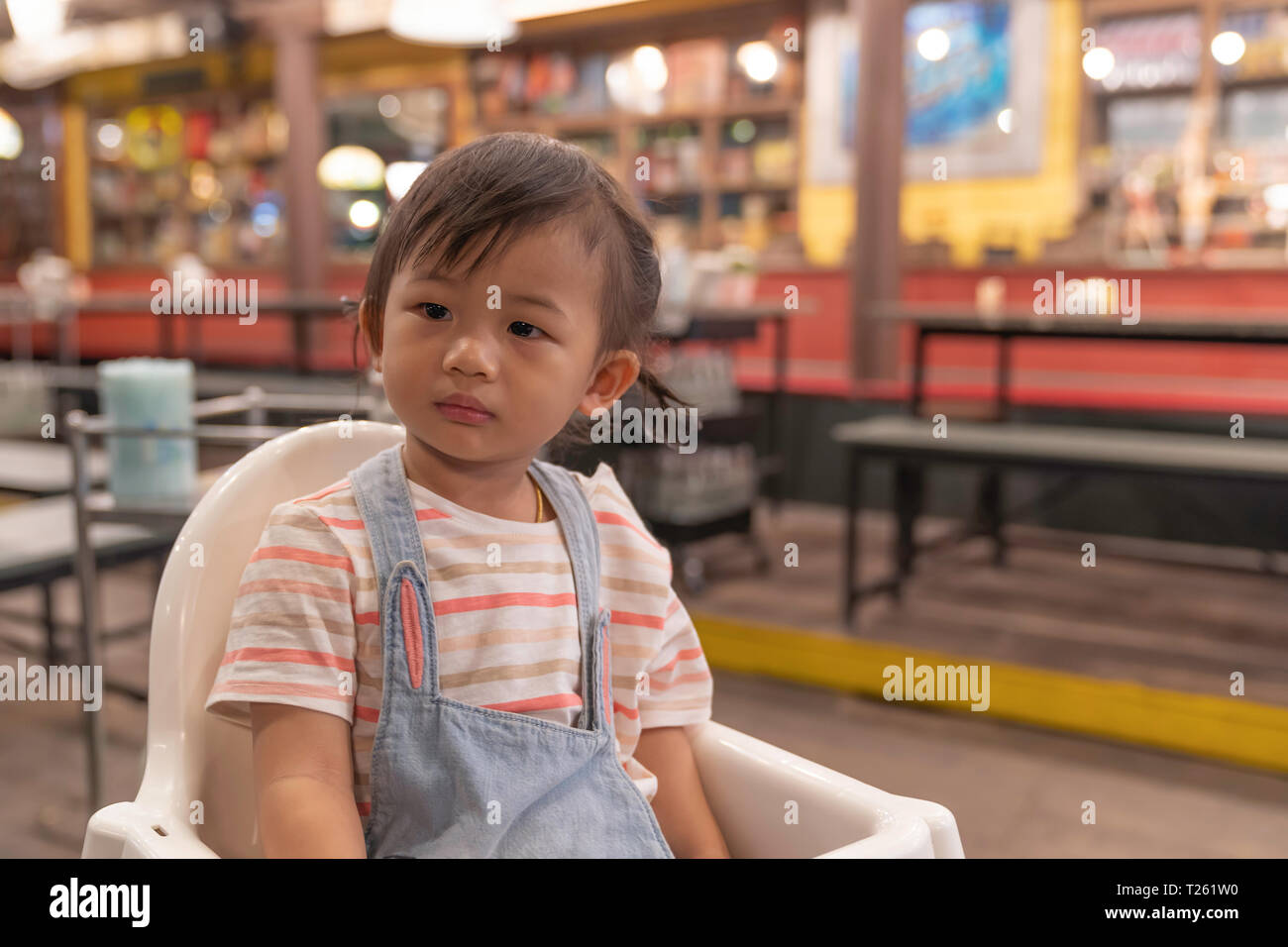 Asian baby girl boring on baby table in restaurant background Stock ...