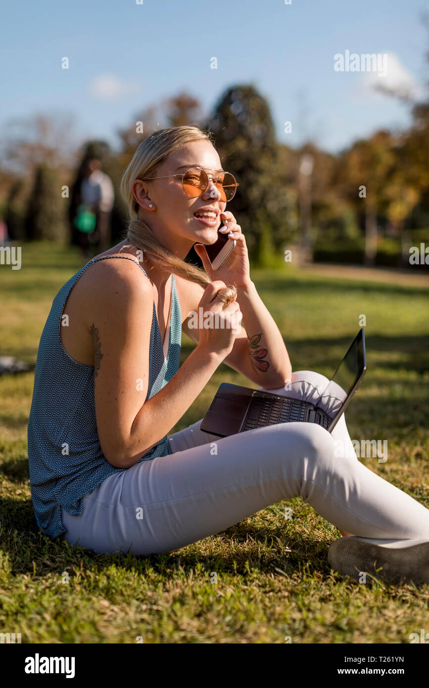 Young woman sitting park hi-res stock photography and images - Alamy