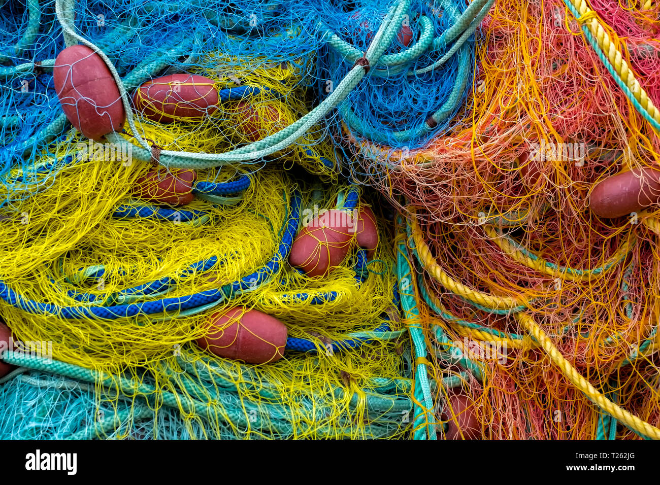 Colourful fishing nets with red buoys Stock Photo - Alamy
