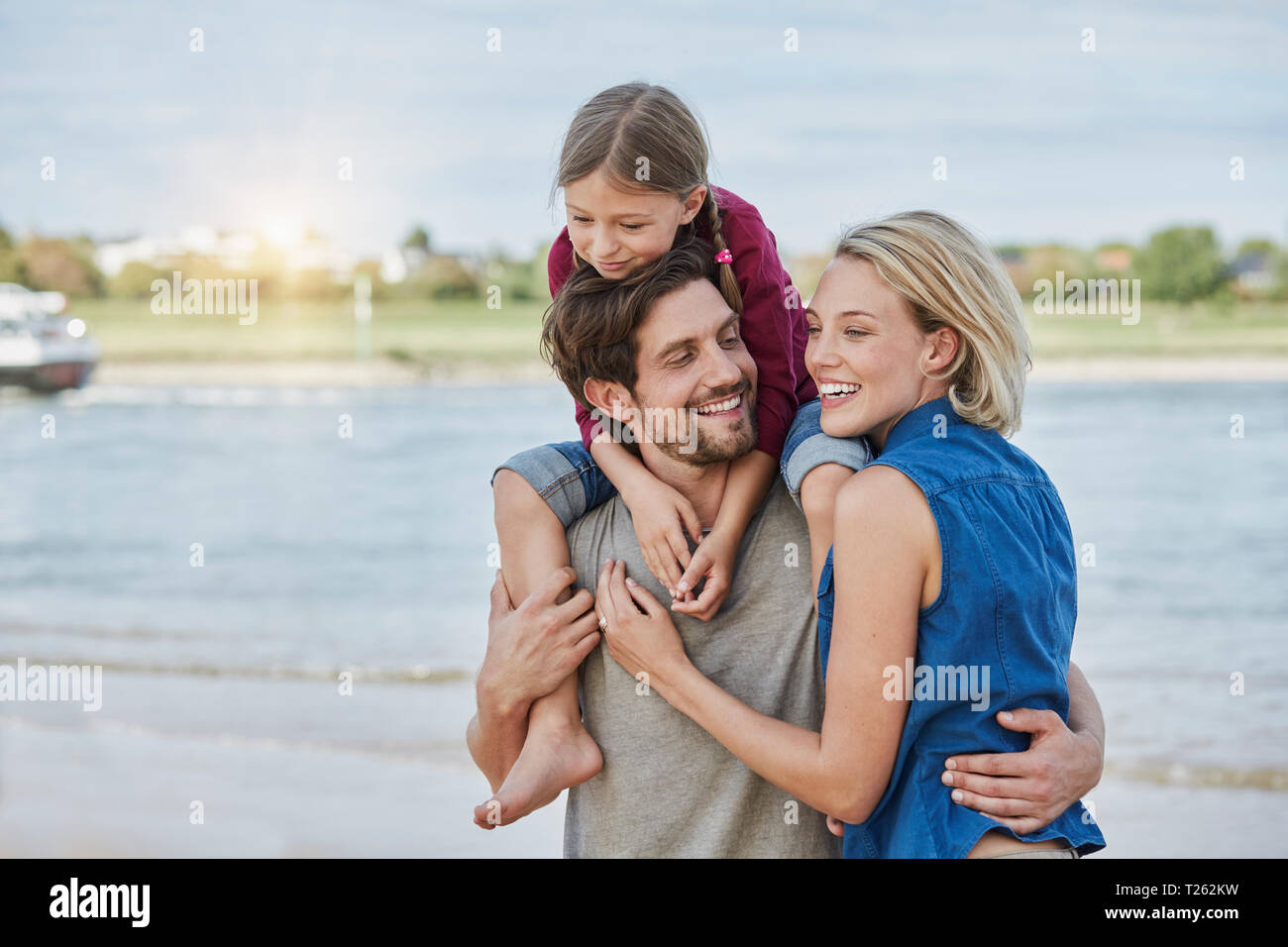 Germany, Duesseldorf, happy family with daughter at Rhine riverbank ...