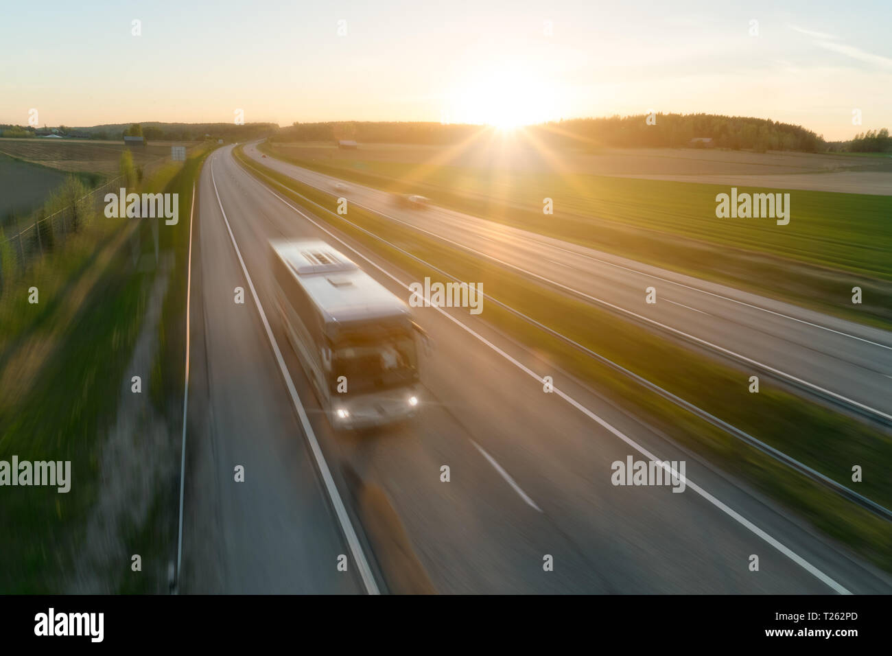 A bus driving on highway against sunset with motion blur effect Stock ...