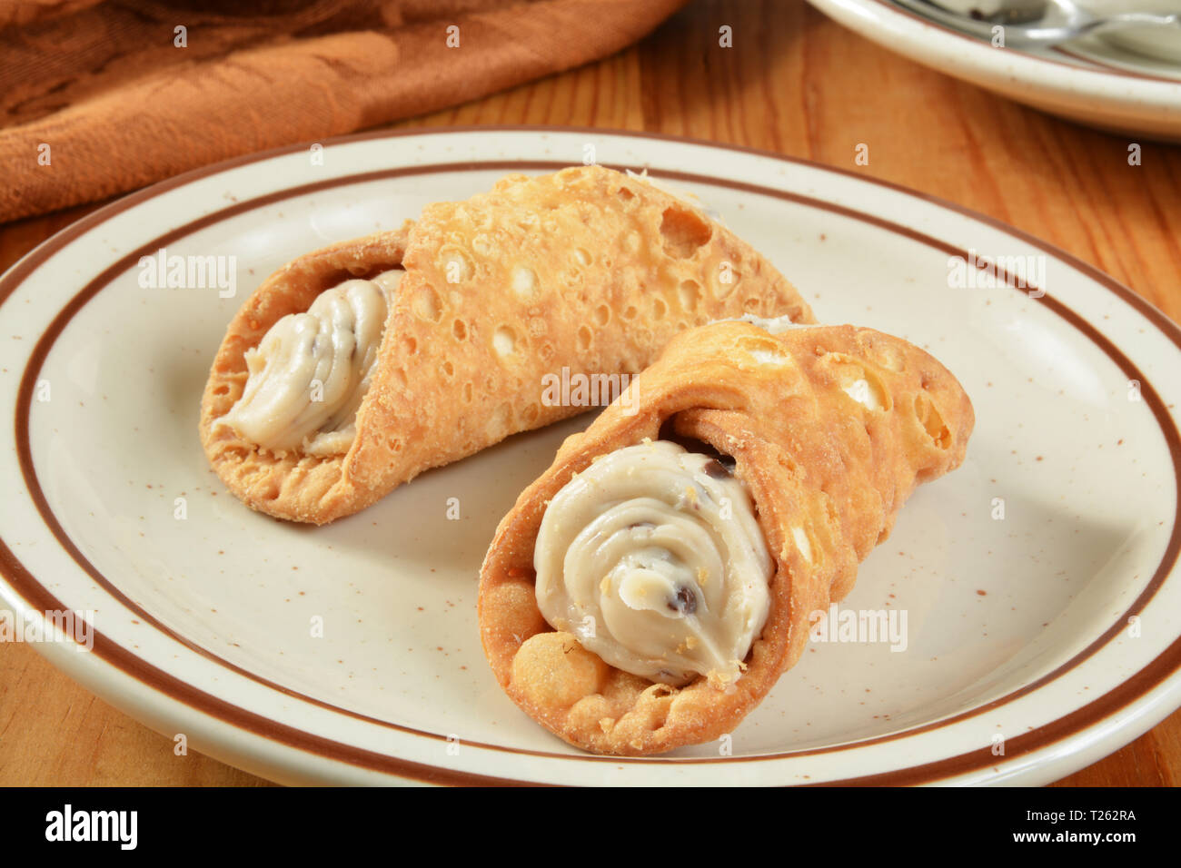 Gourmet vanilla custard and chocolate chip cannoli on a rustic wooden ...