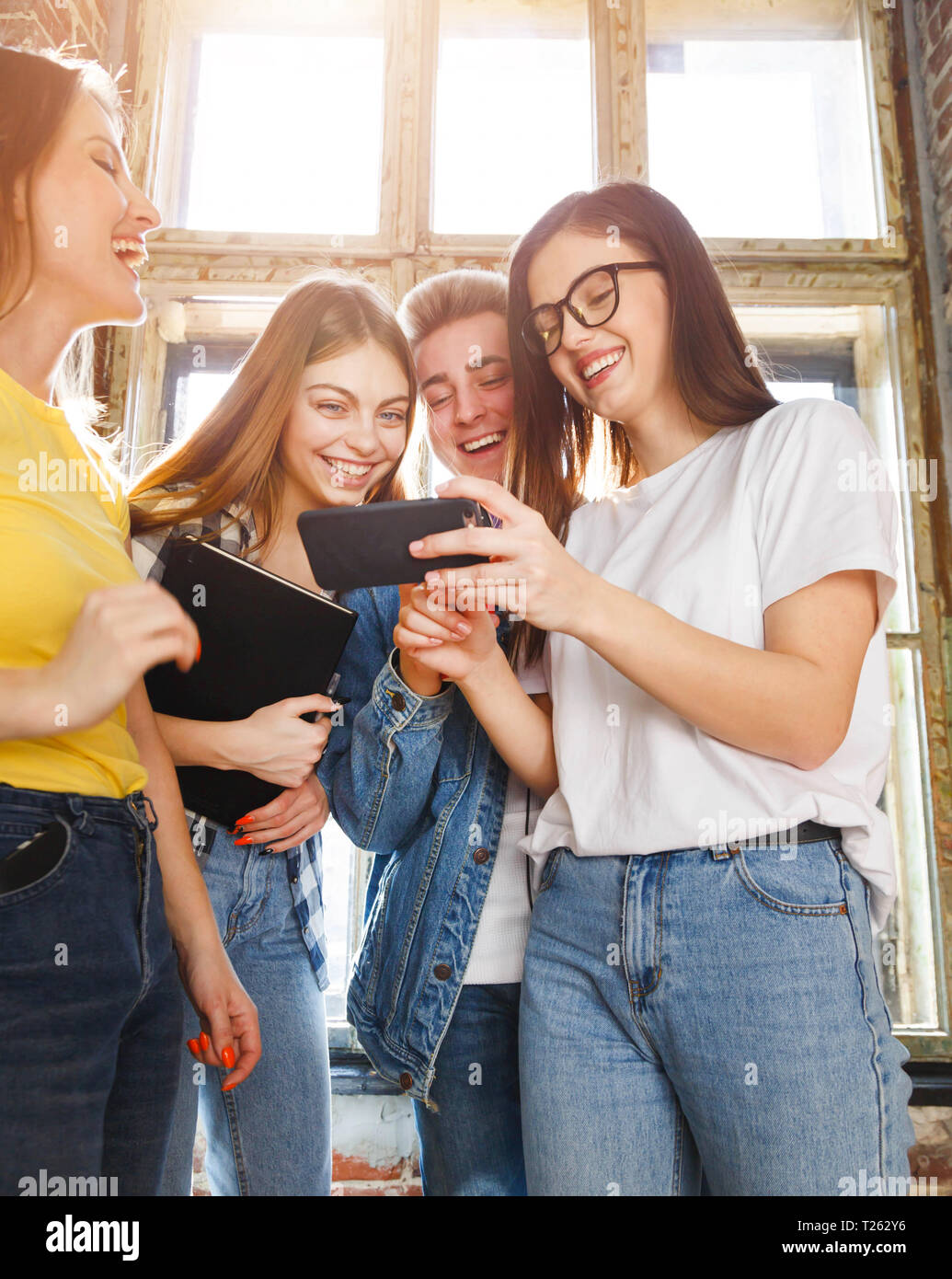 Best friends watching photos on the smartphone and laughing Stock Photo ...