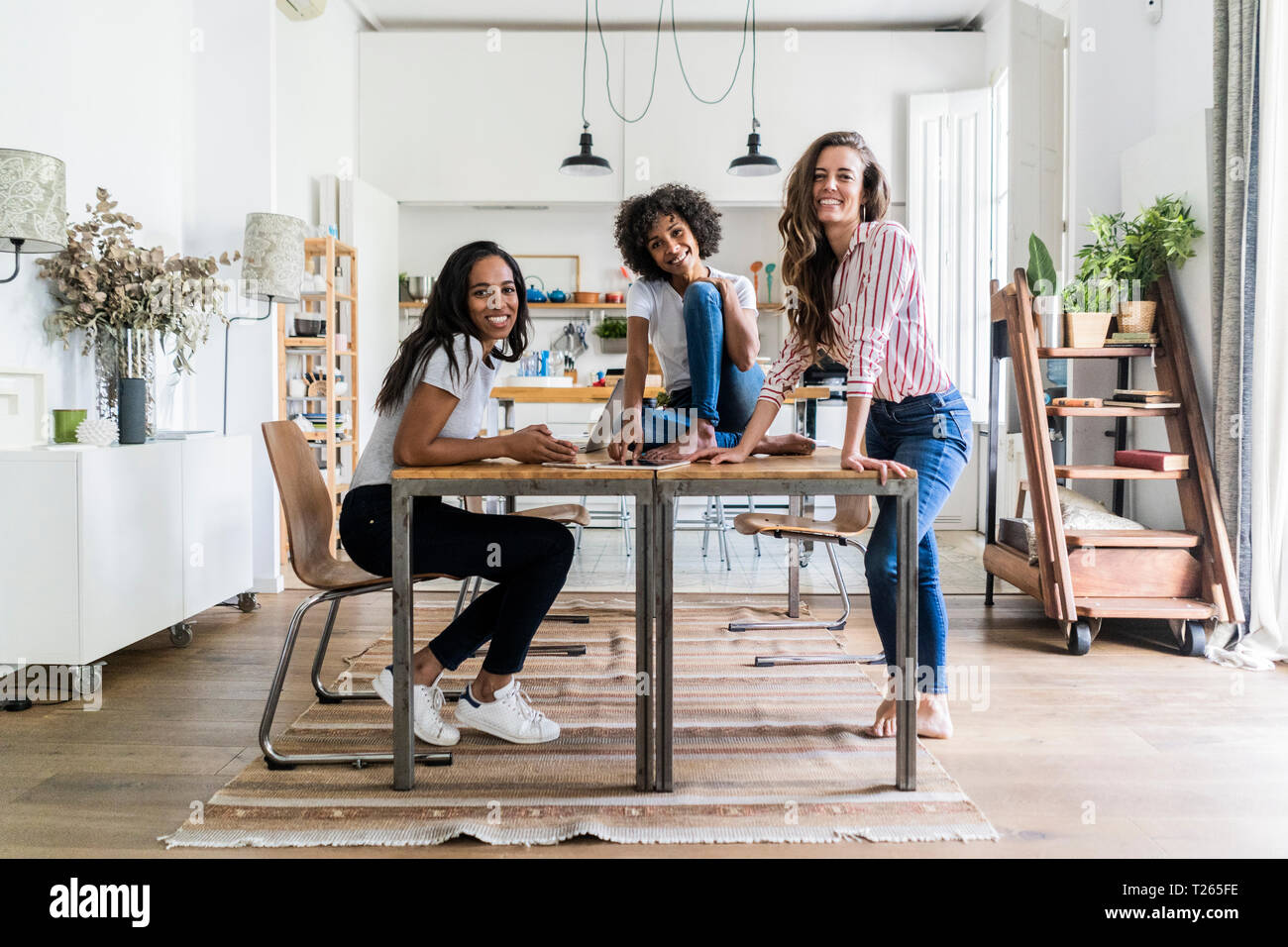 Portrait of three happy women at table at home Stock Photo - Alamy
