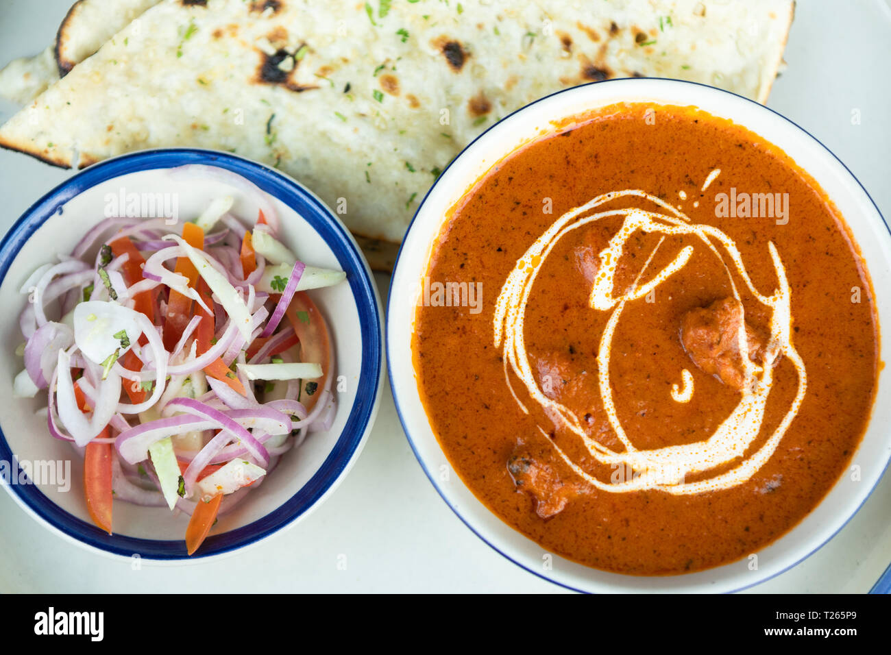 Butter Chicken with naan bread and raita Stock Photo - Alamy