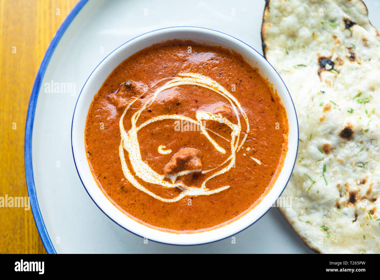 Butter Chicken with naan bread and raita Stock Photo - Alamy